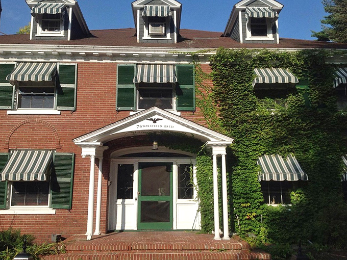 Ivy-covered brick and green shutters create the kind of building that makes you slow down and appreciate architectural good manners.