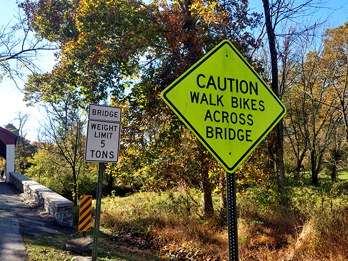 Warning signs remind visitors of the bridge's practical limitations&mdash;a 5-ton weight limit and pedestrian cautions for this working historical artifact.