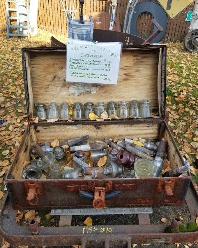 A treasure chest of glass insulators sits among autumn leaves&mdash;telegraph technology turned garden art for the discerning collector.
