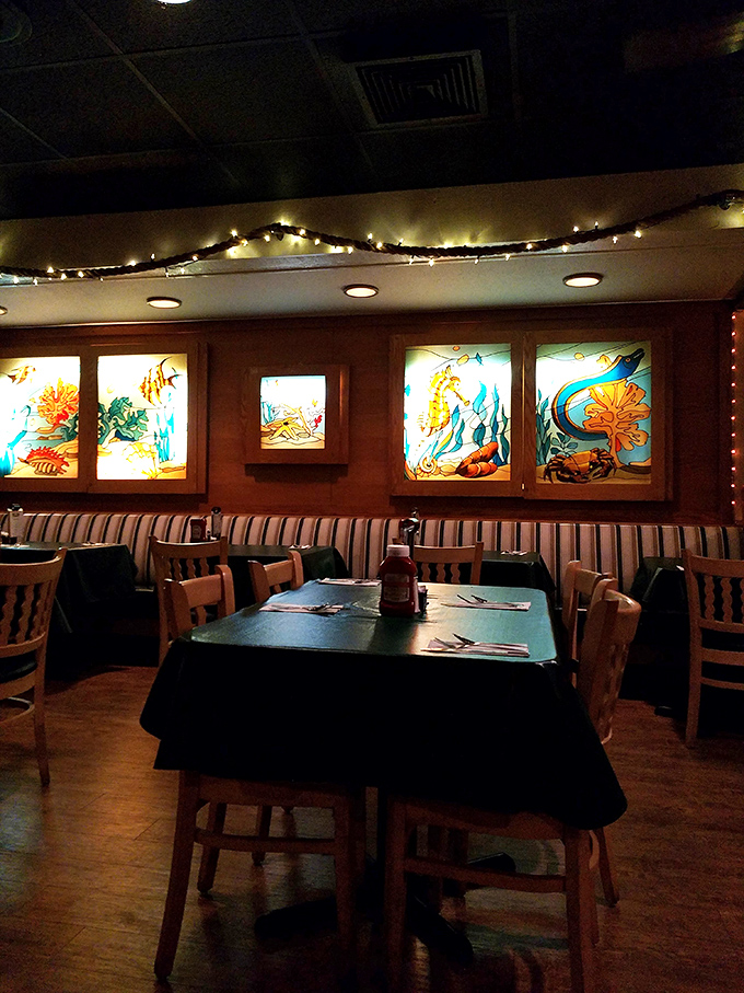 Stained glass underwater scenes cast a warm glow over diners, creating the perfect ambiance for seafood feasting without pretending you're actually on a yacht.