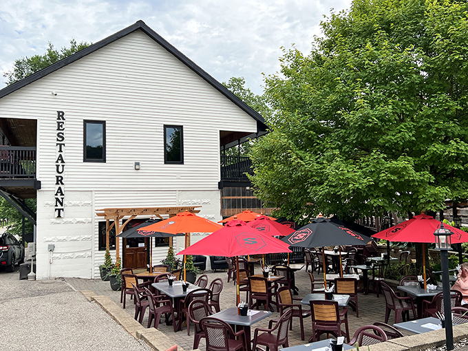Outdoor dining with red umbrellas and riverside ambiance&mdash;because sometimes the best meals taste even better under open skies.