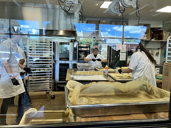 The kitchen window offers a peek into pastry paradise. White-coated wizards transform flour and butter into the treats that make this cafe legendary.