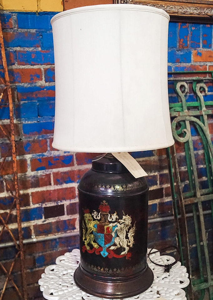 A regal lamp that once illuminated someone's cherished moments. That coat of arms suggests it lit the pages of more than a few good books.