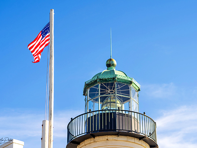 The lantern room's intricate metalwork stands proudly beside Old Glory, a patriotic pairing that screams "maritime Americana" in the best possible way.