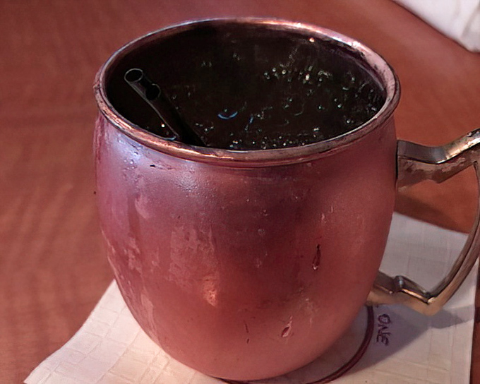 The Moscow Mule arrives in its signature copper mug—cold, refreshing, and photogenic enough to make your social media followers genuinely jealous.