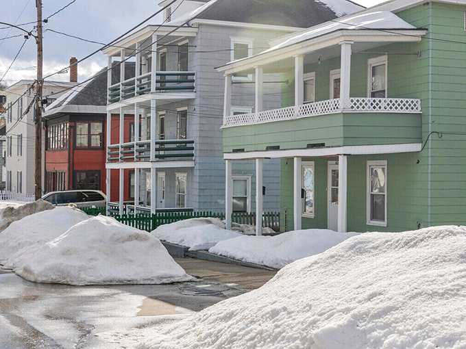 Colorful multi-family homes stand resilient against winter's onslaught, showcasing the practical New England approach to community living.