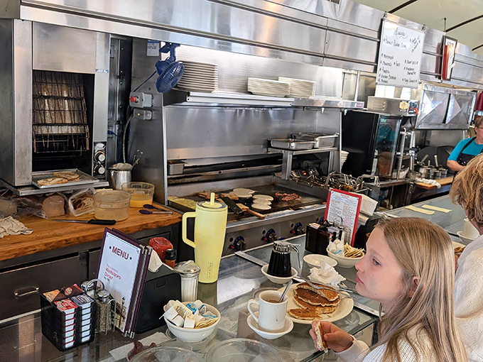 The open kitchen reveals the choreography behind comfort food magic. No smoke and mirrors, just skilled hands turning simple ingredients into memories.