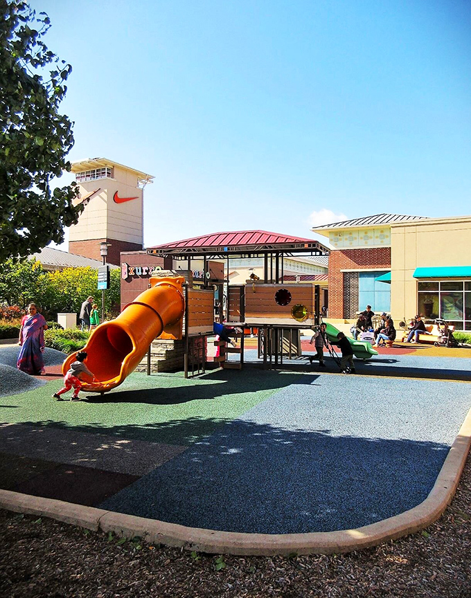 A playground where kids burn energy while parents mentally calculate how many more stores they can hit before meltdowns begin – theirs or the children's.