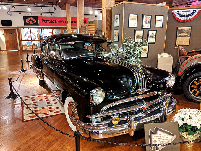 The stately Pontiac Chieftain stands as automotive royalty, its gleaming black finish and chrome details speaking to an era when cars were designed to impress the neighbors. 