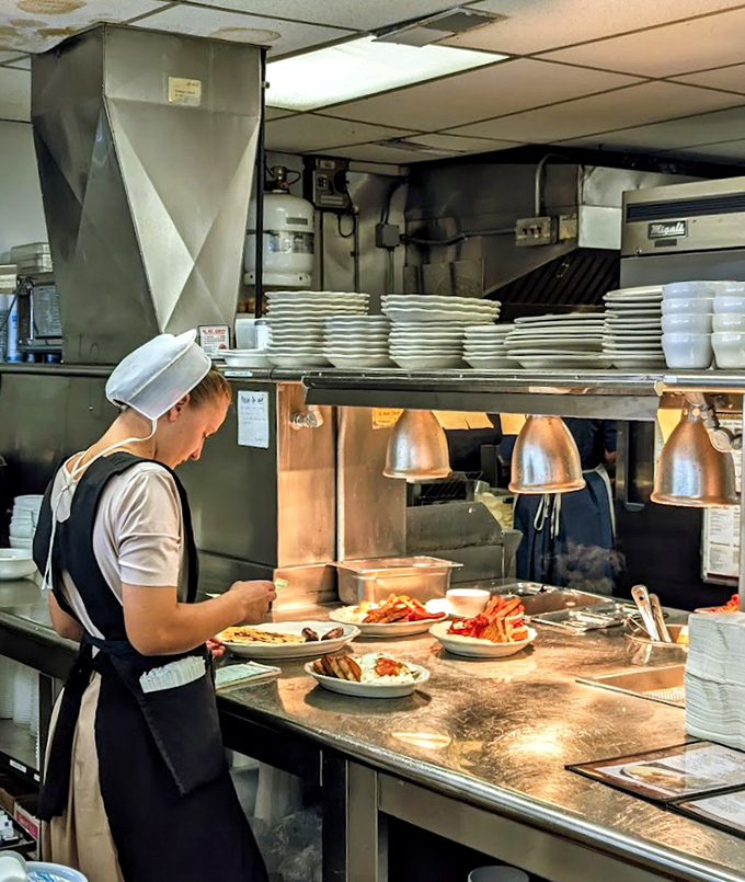 Behind the scenes, skilled hands plate each dish with practiced efficiency &ndash; no fancy tweezers or garnish towers, just honest food done right.