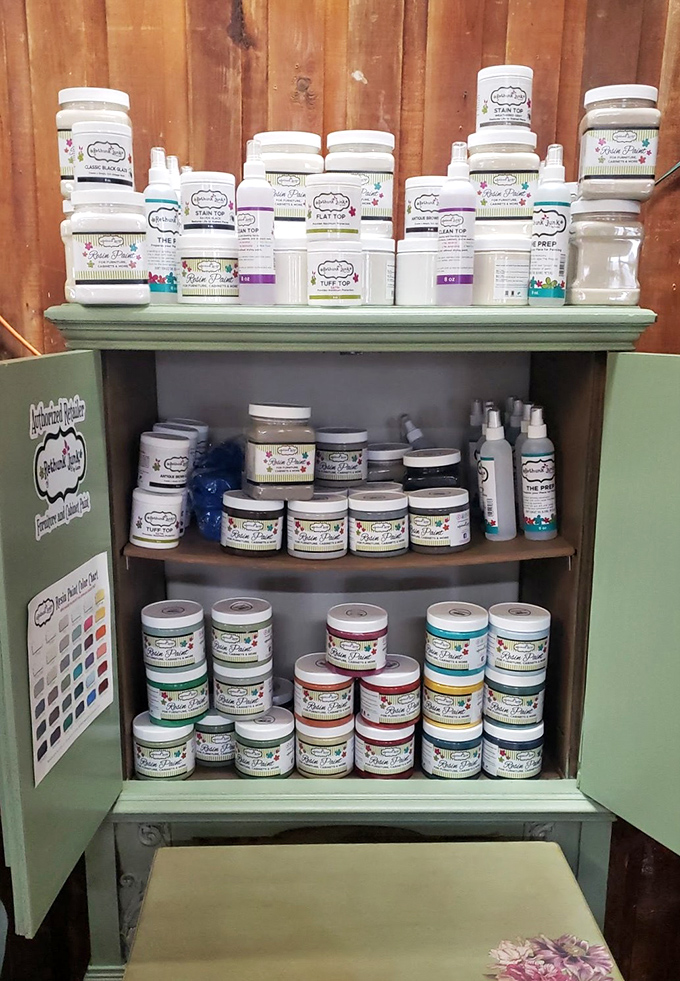Vintage paint supplies in a charming mint cabinet &ndash; where DIY dreams begin and furniture transformations are just a brush stroke away.