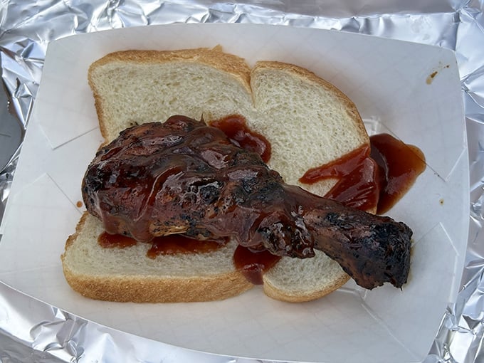 A chicken leg sandwich that doesn't know it's supposed to play second fiddle to brisket. That sauce spread isn't subtle&mdash;it's making a statement.