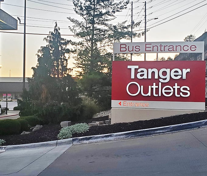 Even at sunset, Tanger's welcoming entrance sign promises retail adventures await. The bus entrance ensures everyone can participate in the bargain bonanza.