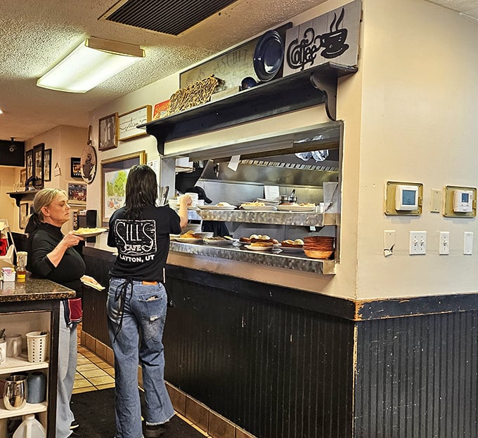 The pick-up window where plates of deliciousness make their journey from kitchen to table with practiced efficiency and genuine care.