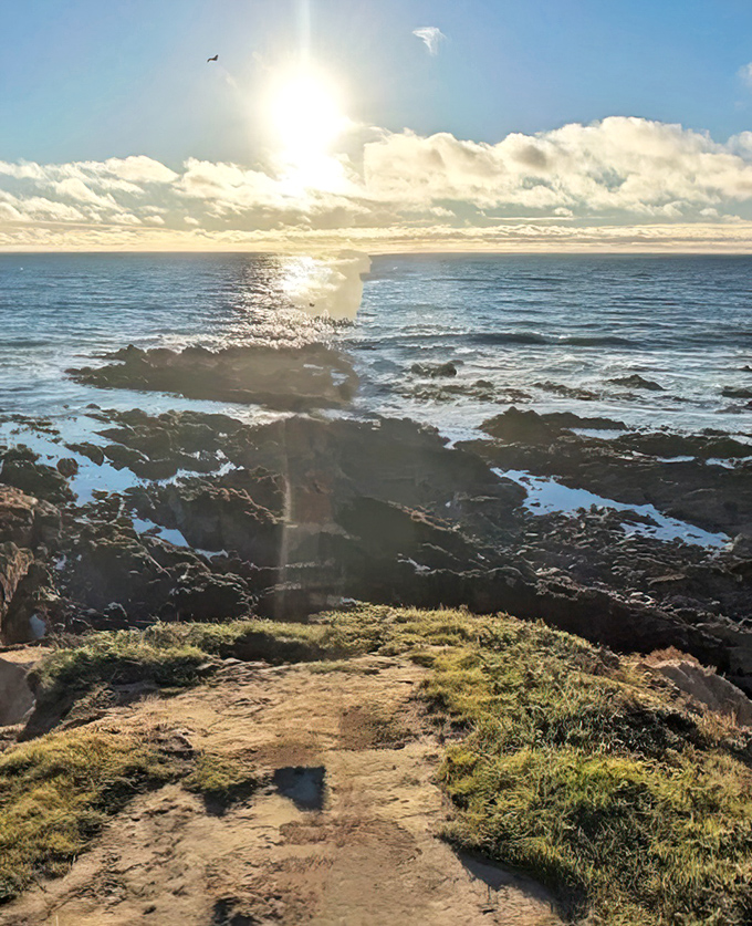 Golden hour transforms the coastline into nature's cathedral, where sunlight streams through clouds like stained glass windows over the Pacific.
