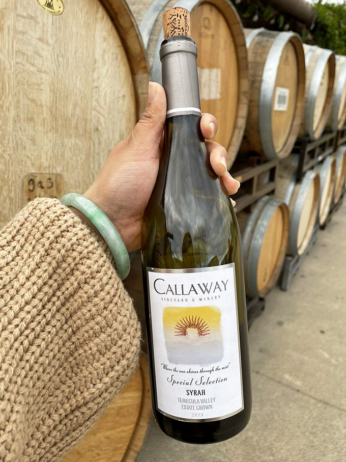 Liquid treasure: A hand cradles Callaway's estate-grown Syrah against a backdrop of aging barrels&mdash;wine country's version of a perfect moment.