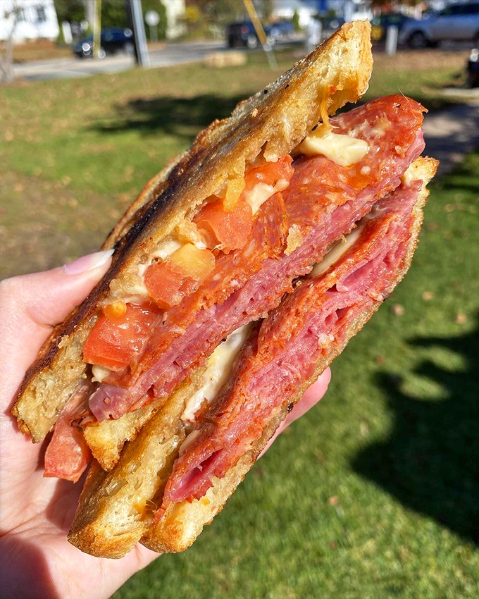 This isn't just a sandwich—it's a skyscraper of meat, cheese, and tomato that makes you wonder if your mouth is actually big enough.