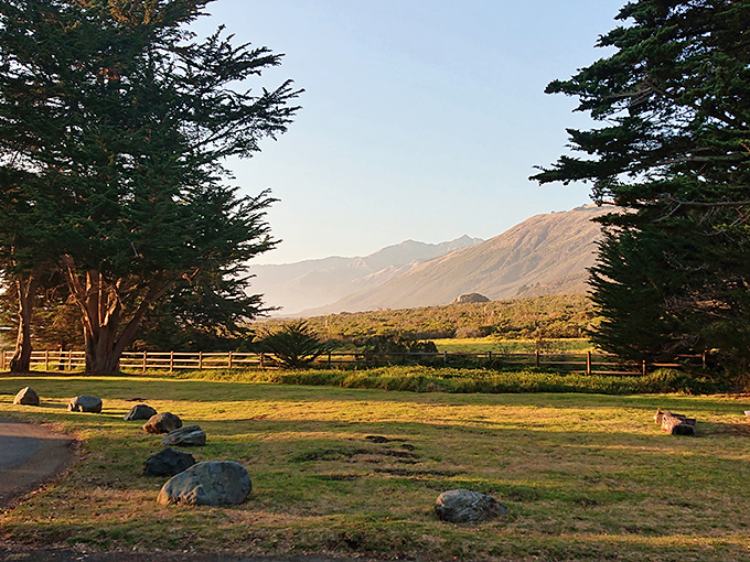 Morning light bathes the coastal mountains in amber glow. The inland view from nearby campgrounds rivals the ocean vistas.