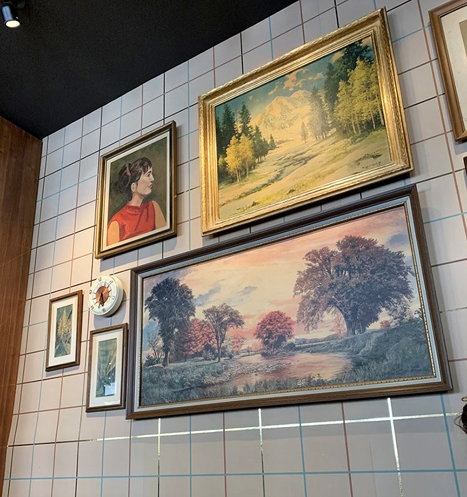 The eclectic wall art collection feels like you're dining in someone's stylish home rather than a restaurant. Those vintage landscape paintings add unexpected character.