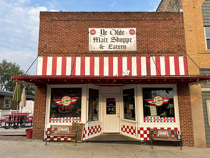 Ye Olde Malt Shoppe's red-and-white striped awning promises ice cream and nostalgia in equal, generous portions. 