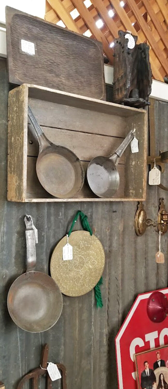 Cast iron cookware that's survived decades of use hangs ready for a new kitchen, carrying the seasoning and stories of countless meals.