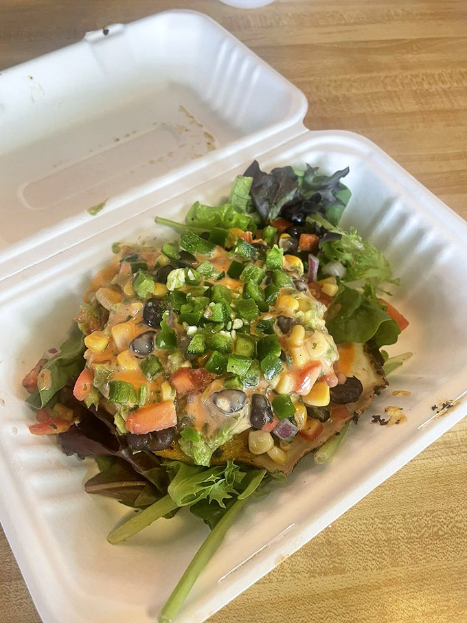 An arepa that bridges cultures and satisfies cravings, topped with a garden of fresh vegetables.