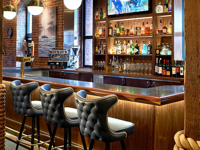 The bar beckons with plush seating and warm wood tones, promising craft cocktails and local wines to complement your seafood feast.