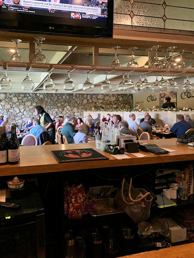 Wine glasses hang like crystal stalactites above the bar, where patrons gather to debate the eternal question: seafood or steak tonight? 