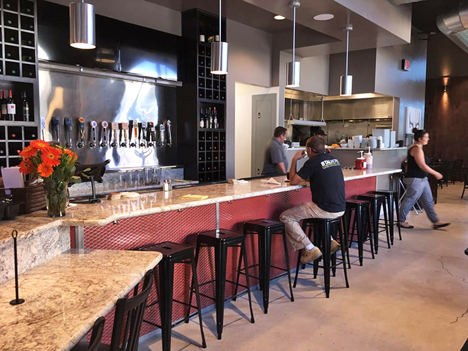 The bar area gleams with promise&mdash;craft beers on tap ready to complement smoky flavors. Those stools have witnessed countless "first bite" expressions of pure joy.