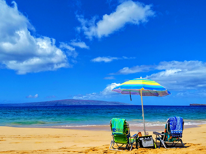 Beach real estate at its finest – two chairs, one umbrella, and an endless blue canvas that no penthouse view can match.