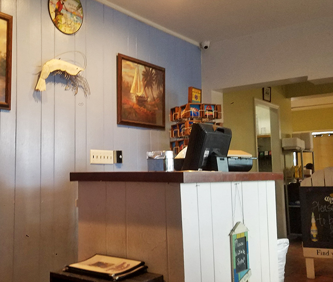 The humble check-in area where seafood dreams begin. Notice the coastal artwork &ndash; they're setting the mood before you even sit down.