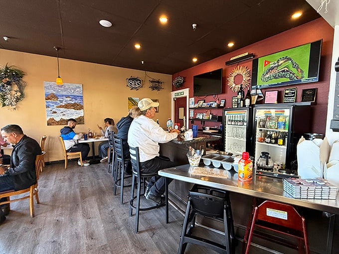 The counter where regulars perch like breakfast philosophers. Morning wisdom flows as freely as the coffee refills in this cozy corner.