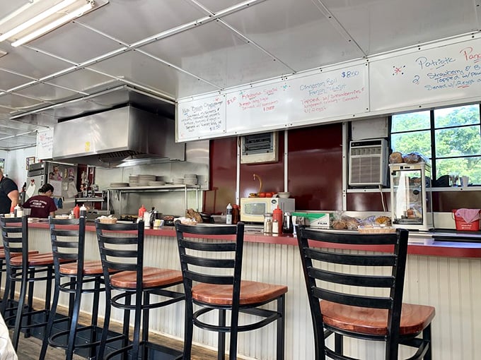 The counter view reveals the command center where breakfast dreams come true, complete with handwritten specials that change daily but never disappoint.
