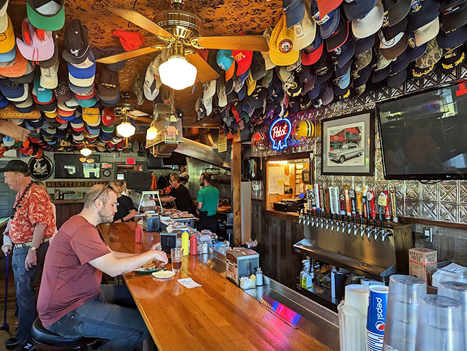 The bar where magic happens&mdash;cold beer flows and stories are exchanged under a colorful canopy of caps collected over decades.