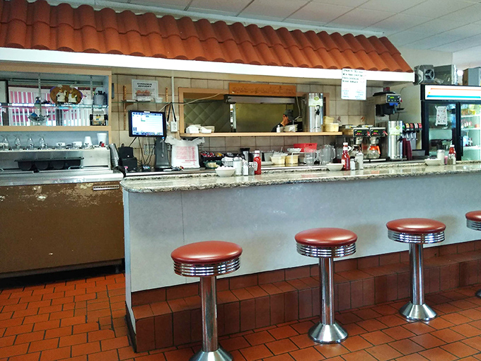 The counter and stools—where solo diners become temporary neighbors and the short-order ballet unfolds before appreciative audiences.