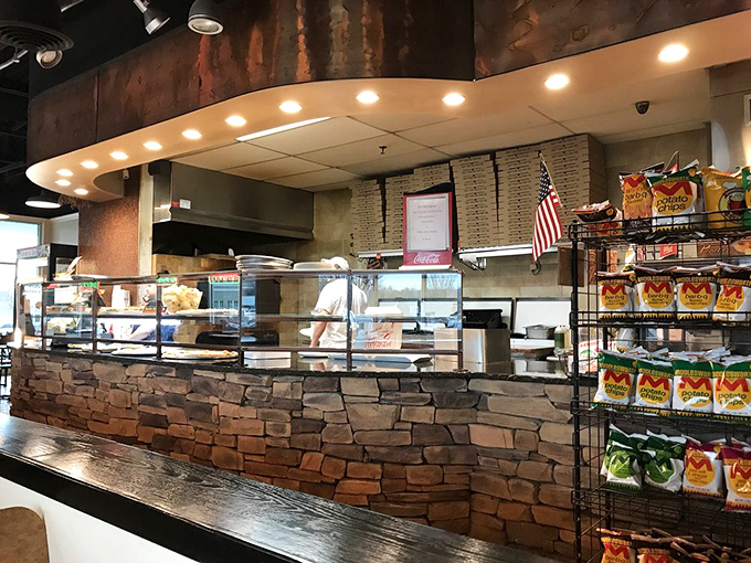 The heart of operations where pizza dreams come true. Stone facade meets modern efficiency in this open kitchen design.