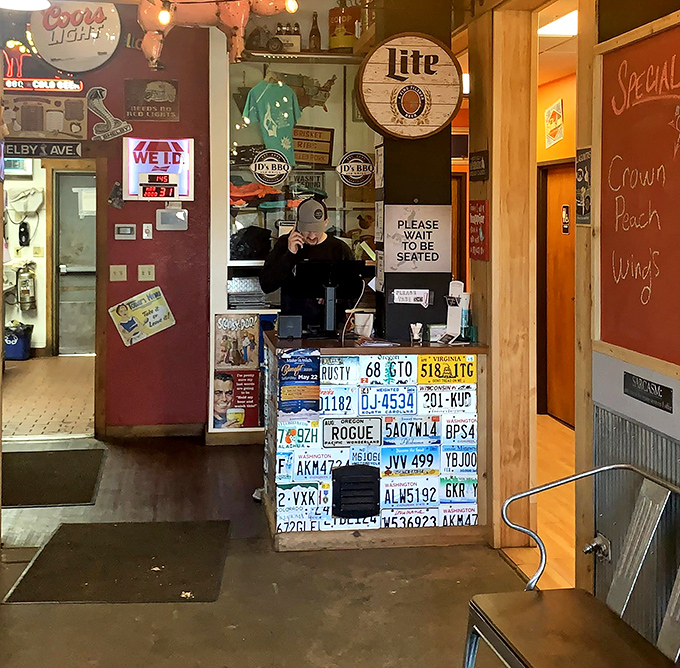 The host stand decorated with license plates from visitors far and wide&mdash;each one a metal testimony to the pulling power of proper BBQ.