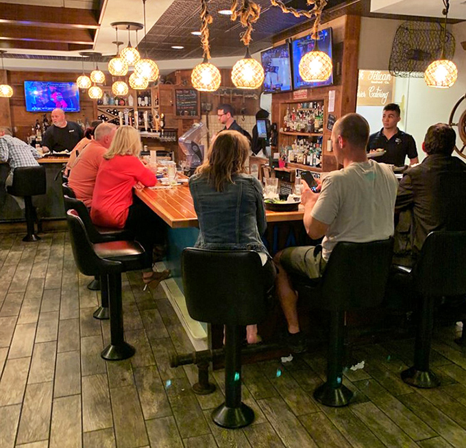 The bar isn't just where drinks are served; it's where strangers become friends. Those globe lights cast the perfect "stay awhile" glow.