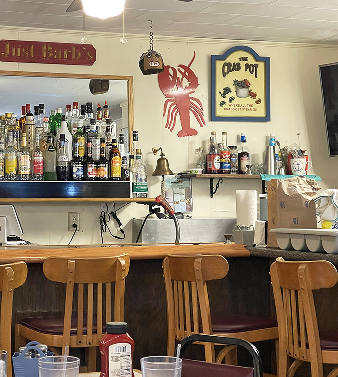 The bar area, complete with wooden stools and nautical decorations, offers a front-row seat to the convivial spirit of this beloved eatery.