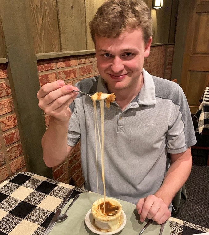 The face of pure joy when French onion soup strings refuse to break. Some dining experiences are worth the cheese-pull struggle.