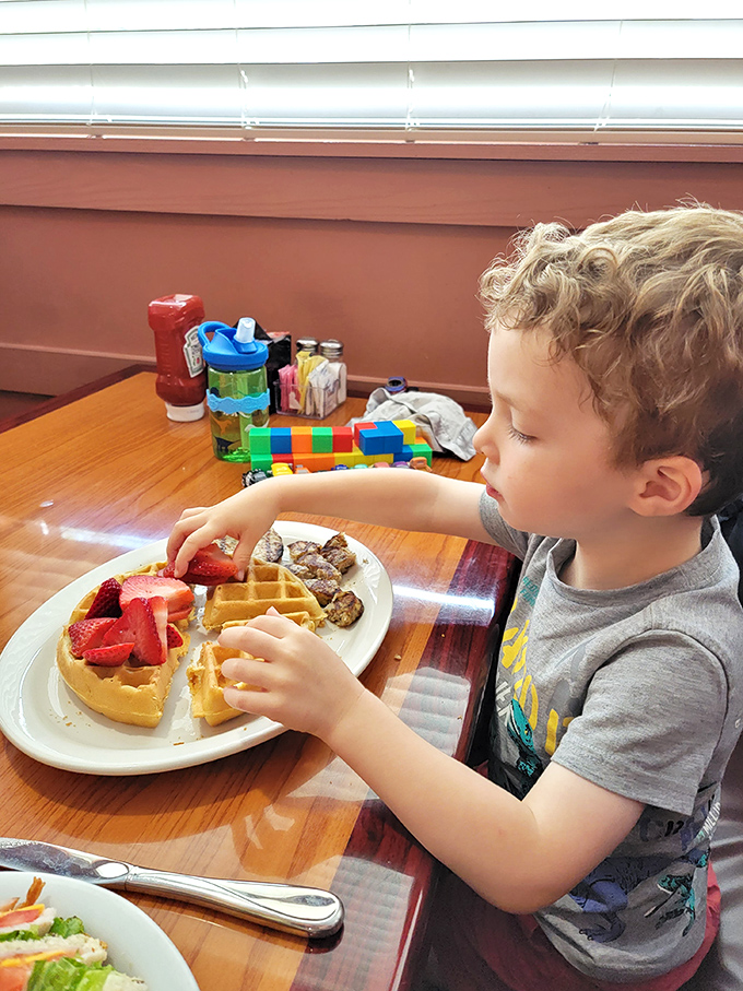 Young waffle enthusiast demonstrates proper strawberry-to-waffle ratio &ndash; the next generation gets it.