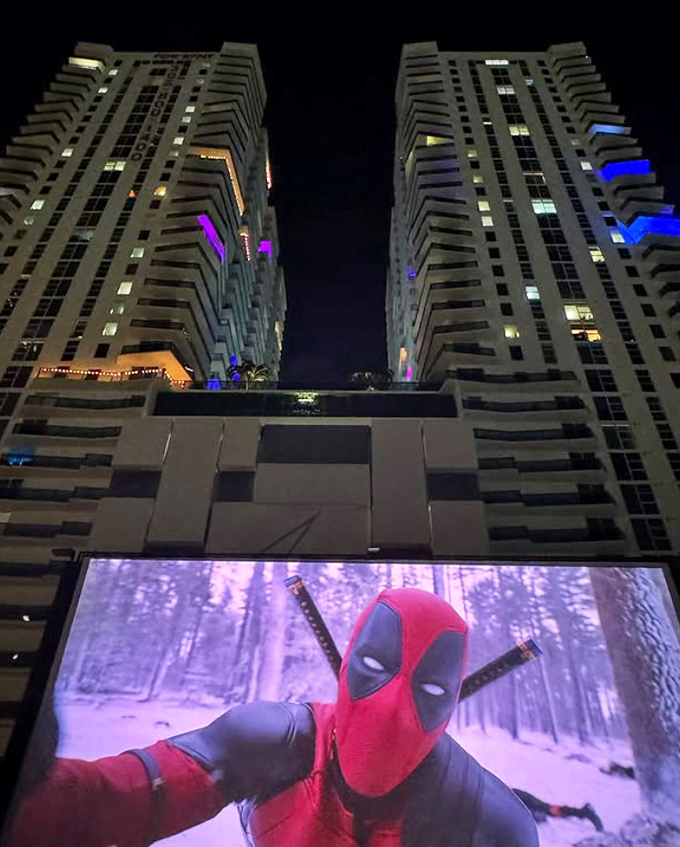 Deadpool breaks the fourth wall and Miami's skyline simultaneously, bringing superhero irreverence to this thoroughly modern drive-in experience.