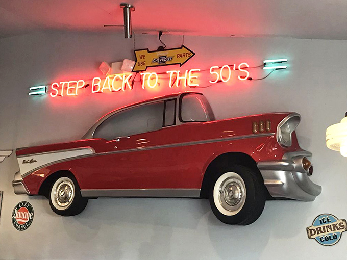 That neon "STEP BACK TO THE 50'S" sign isn't kidding. This classic car display sets the tone for your nostalgic dining adventure.