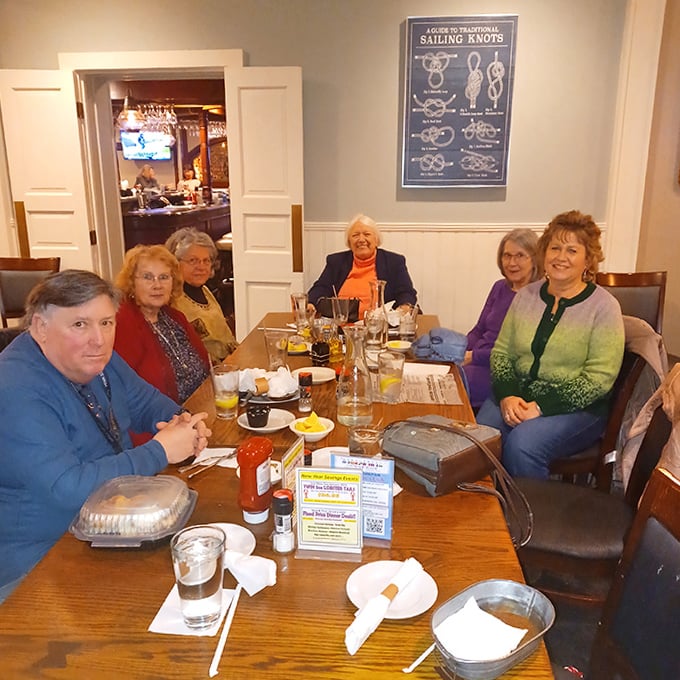 Happy diners gathered around a feast of seafood treasures. The table's wooden surface has probably witnessed thousands of "this is amazing" declarations.
