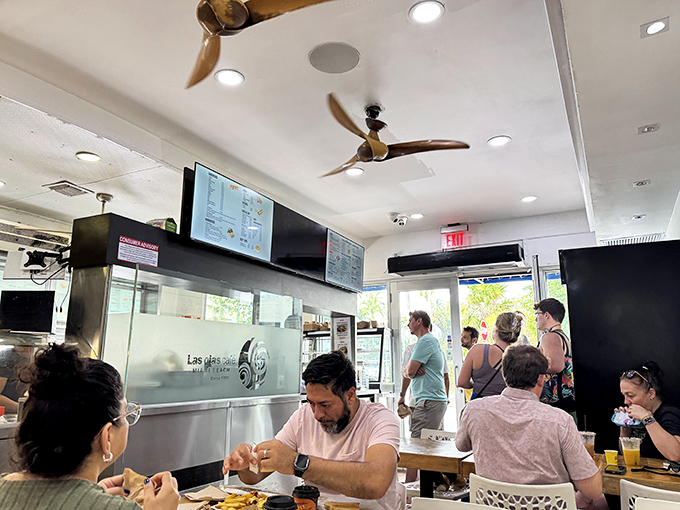The cafe buzzes with energy as diners enjoy their Cuban feasts under wooden ceiling fans that keep the Miami heat at bay.