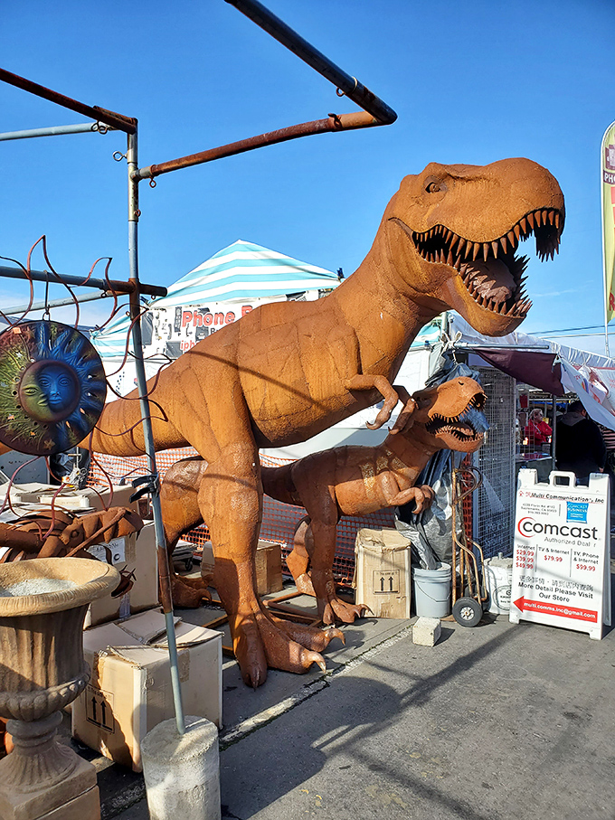 A life-sized dinosaur statue guards this vendor's space, because nothing says "buy my garden decor" quite like a T-Rex.