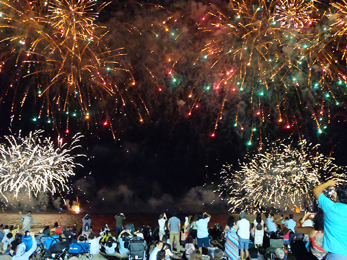 Fireworks paint the night sky as beachgoers become silhouettes against the spectacle&mdash;summer's grand finale written in sparks and wonder.