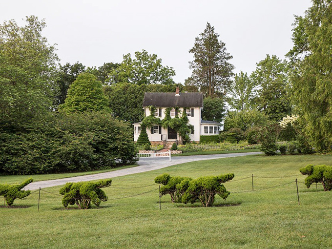 The historic manor peeks through the greenery, like a stately neighbor wondering what all the garden fuss is about.