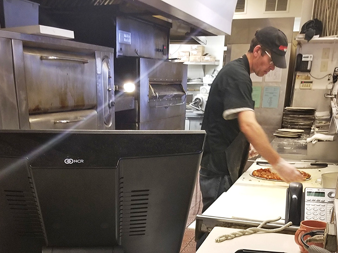 Behind the scenes magic happens here, where dough becomes destiny in the hands of Tommy's pizza artisans.