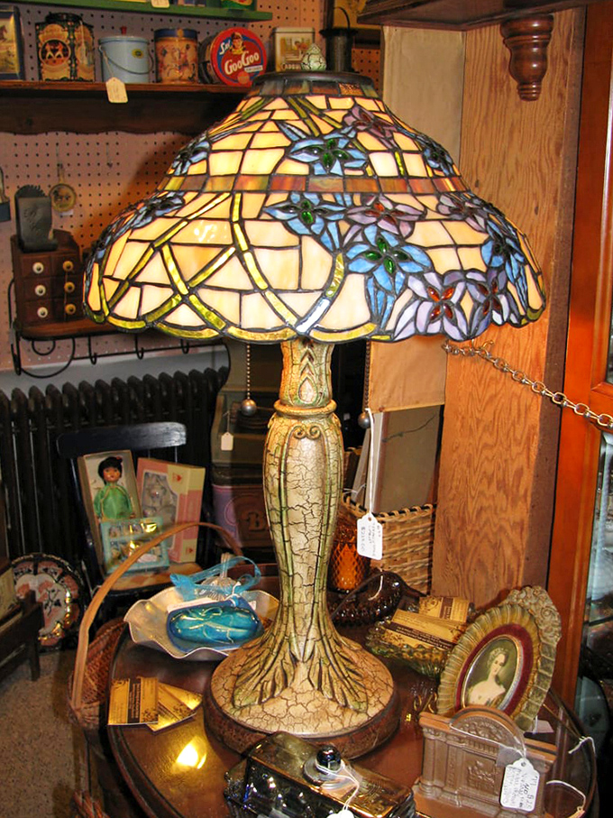 A Tiffany-style lamp glows like a stained-glass sunset, illuminating surrounding vintage treasures with warm light.